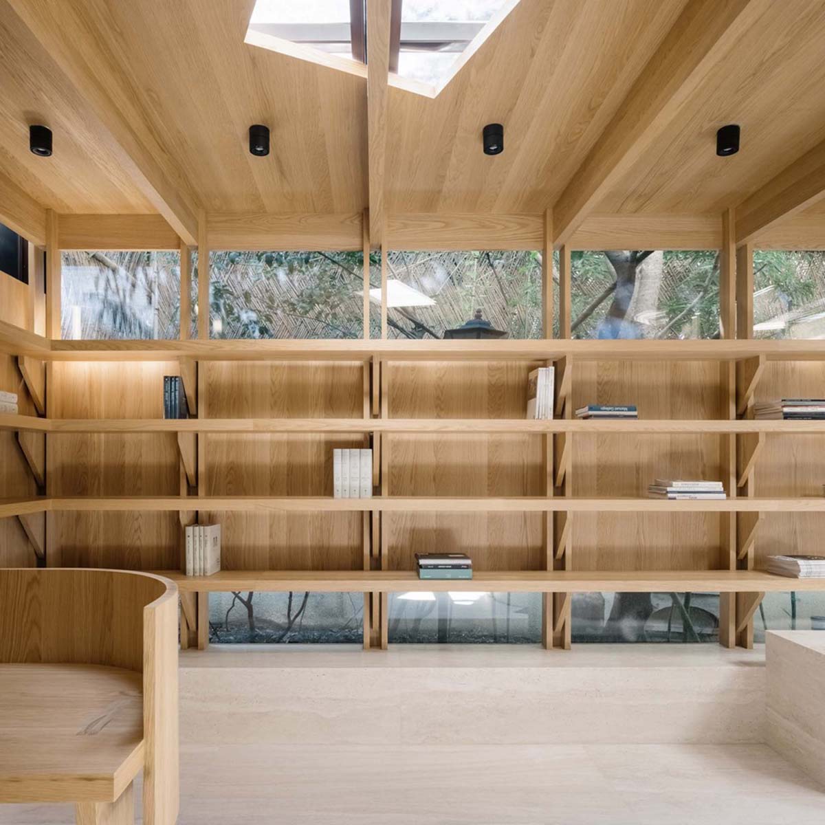 Atelier tao+c creates reading room with semi-circular bookshelves and ...
