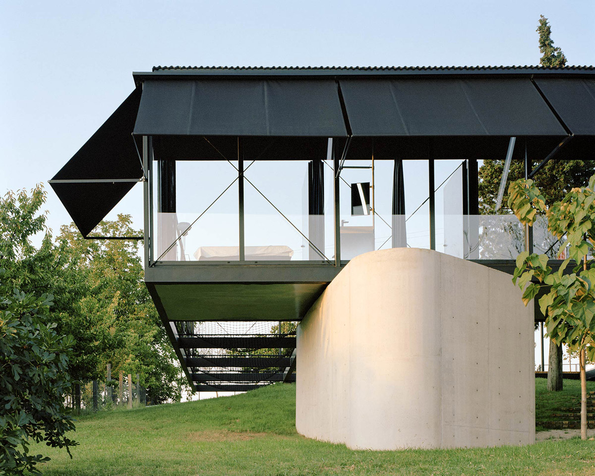 Avala House by TEN is a fully-glazed house supported by slope and ...